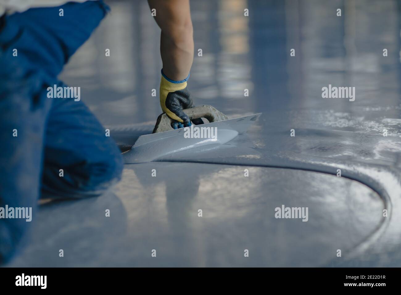 The worker applies gray epoxy resin to the new floor Stock Photo - Alamy