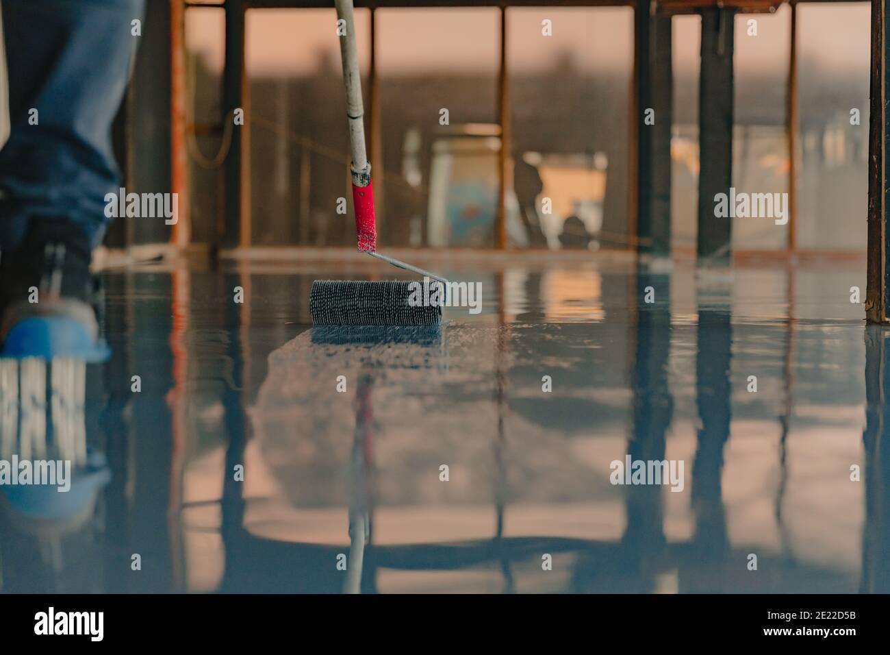 The worker applies gray epoxy resin to the new floor Stock Photo - Alamy