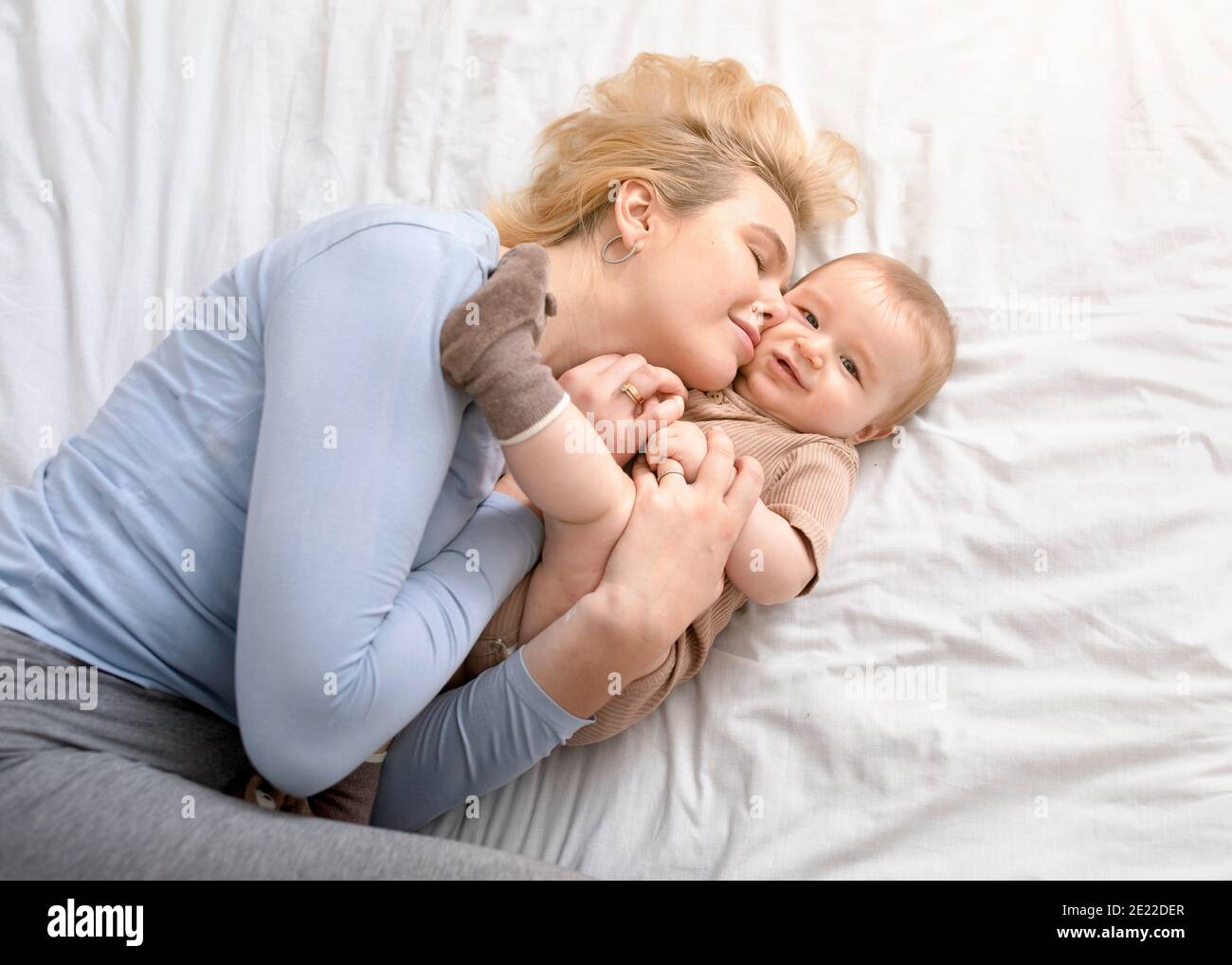 Loving mother caressing her baby boy on bed Stock Photo - Alamy