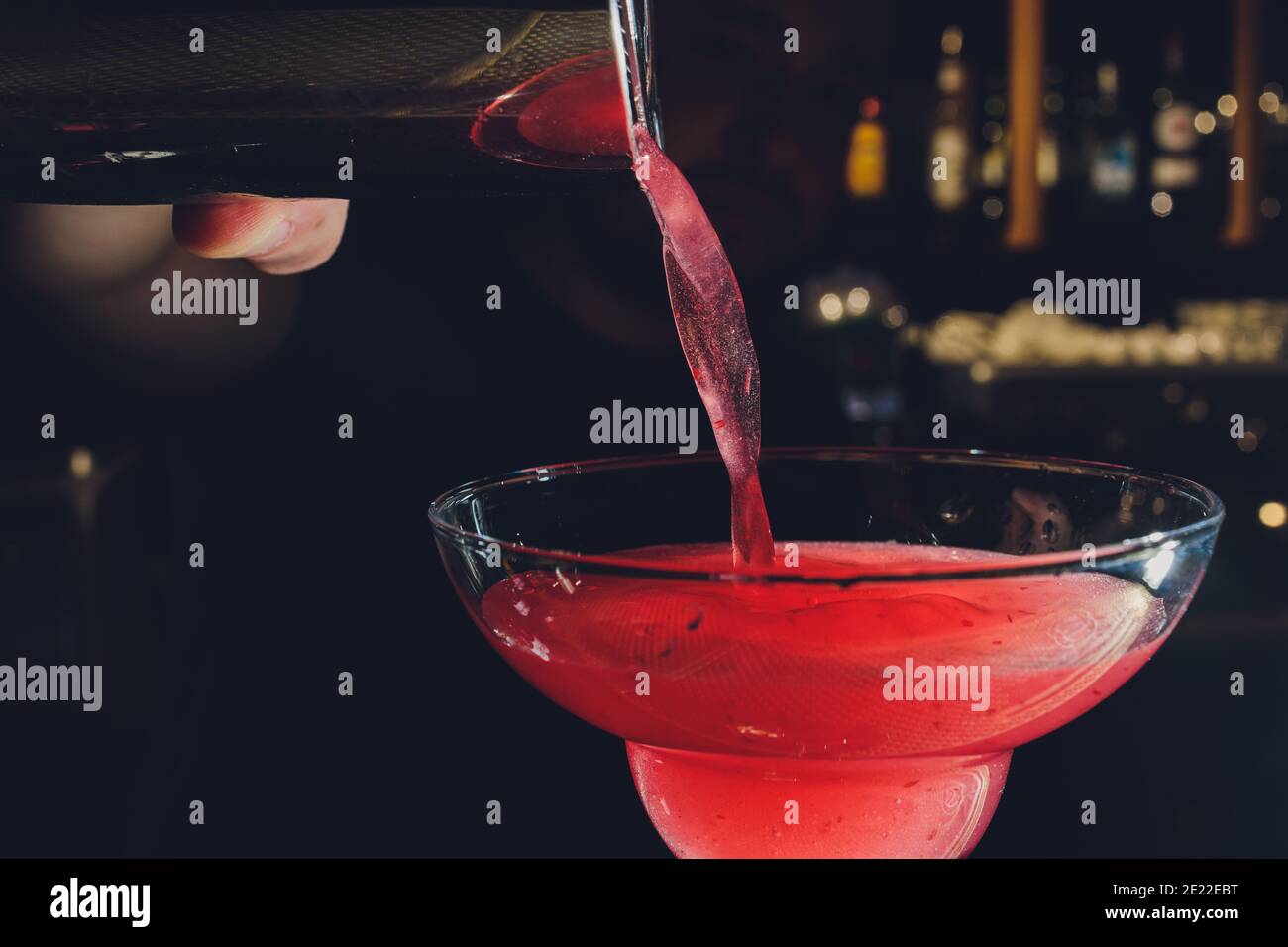 Close up details of barman pouring vodka cosmopolitan cocktail in ...