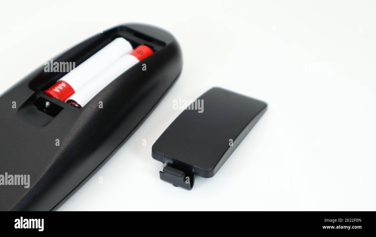 Black TV remote control with AAA alkaline batteries in red and white on ...