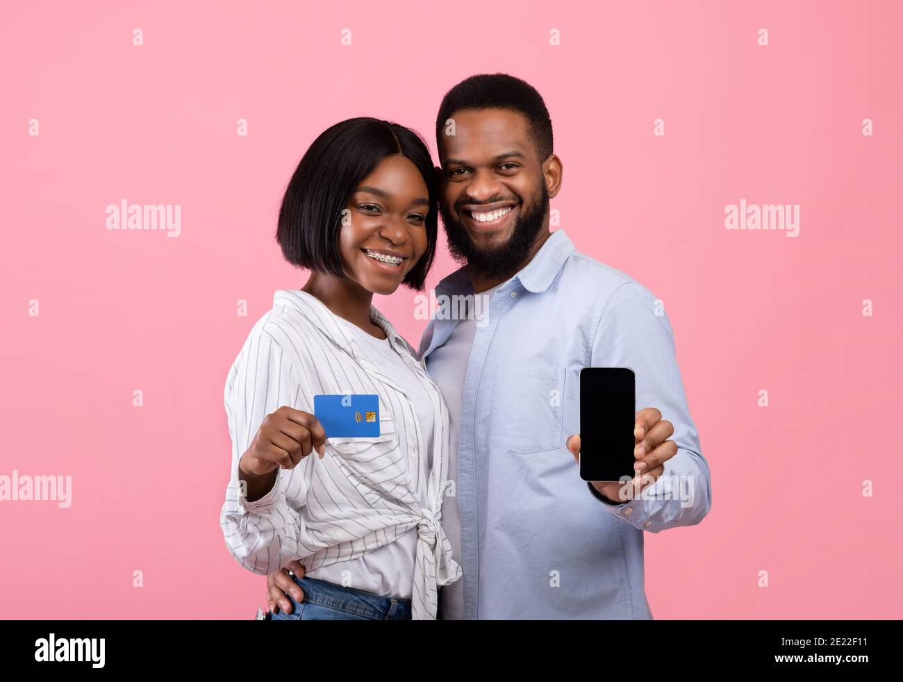 Black couple holding credit card and smartphone with empty screen on ...