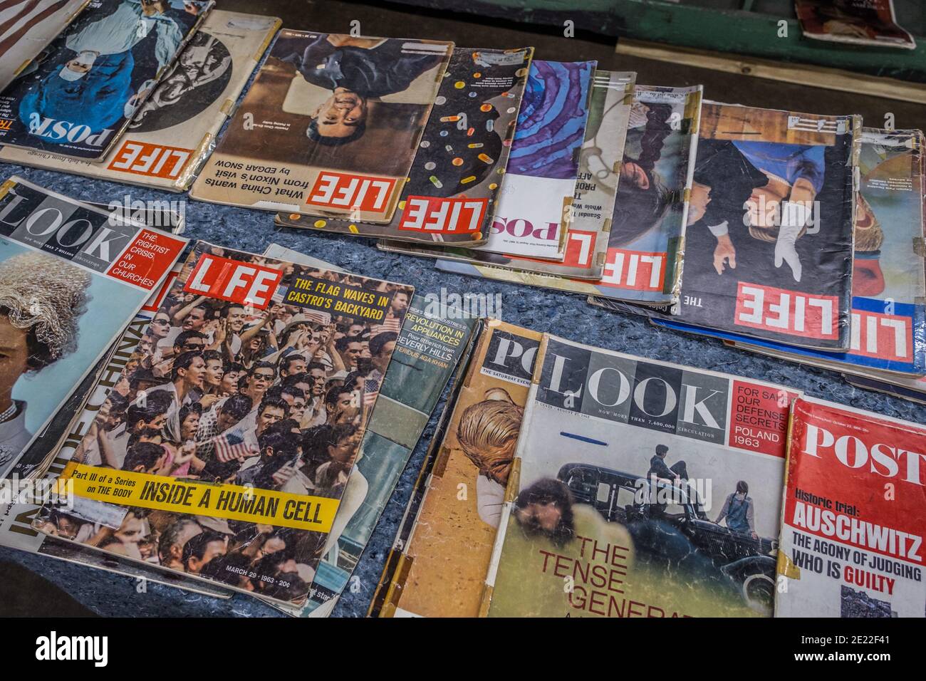A pile of random vintage magazines laying flat on a table on display ...