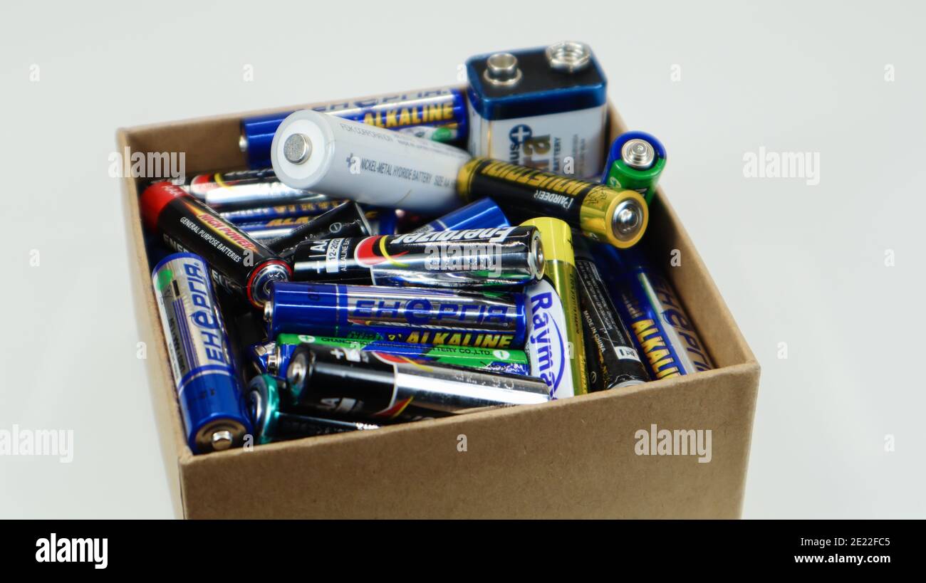 A cardboard box on a white background full of used household AA, AAA ...