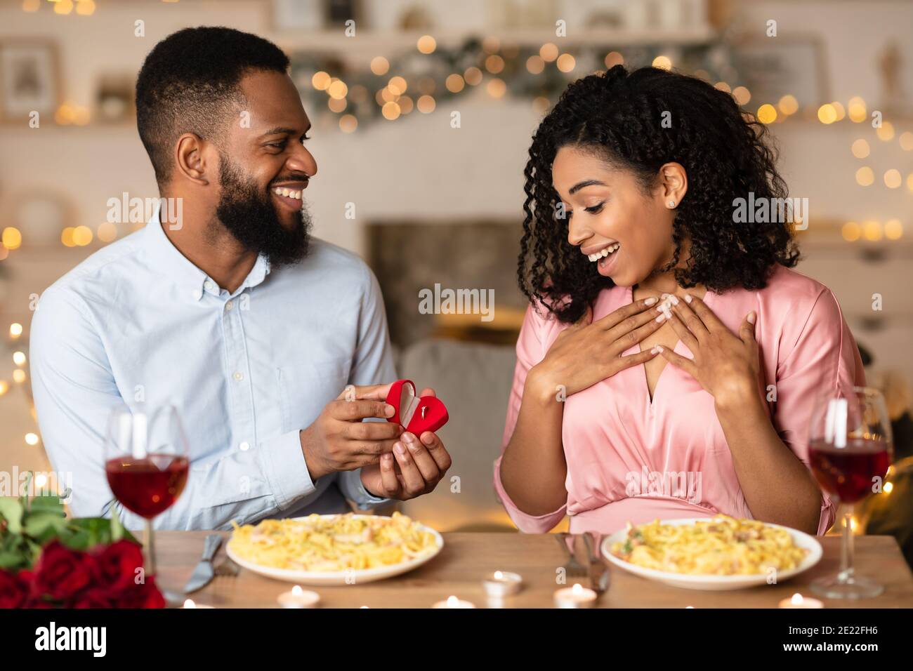 Smiling black man making proposal with ring to his fiance Stock Photo ...
