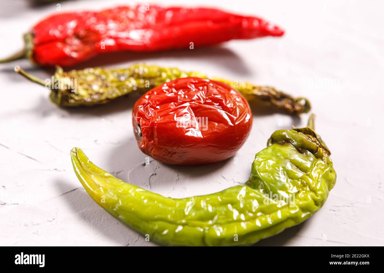 Chili peppers and tomatoes are spoiled, shriveled and rotten. Ugly food ...