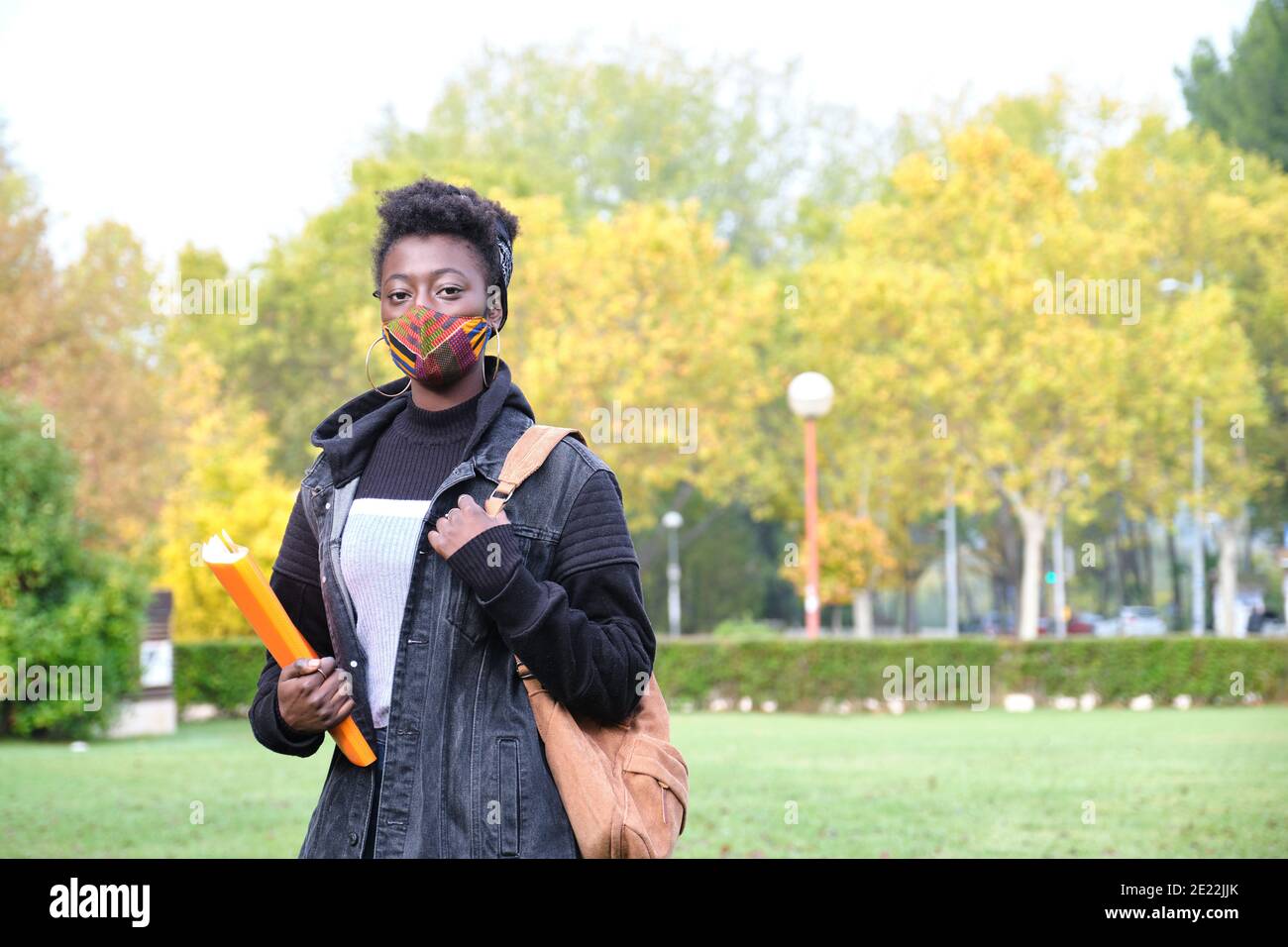 University female african student wearing protective face mask outside ...