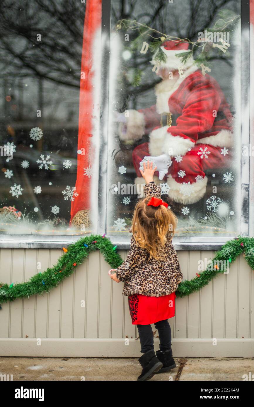 Toddler reaches for santa through window Stock Photo - Alamy
