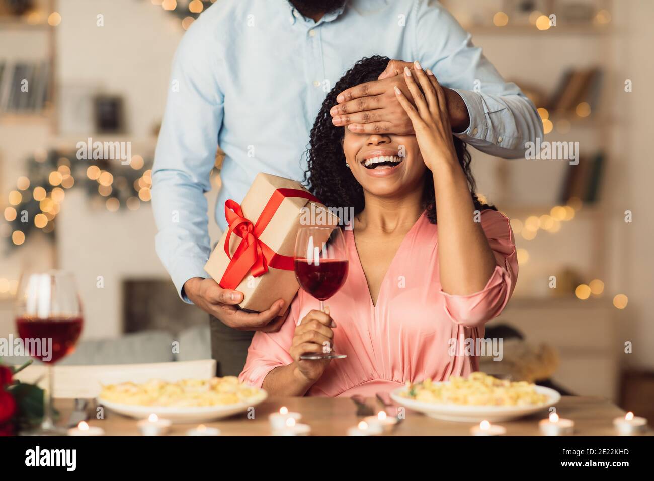 Black man giving box to woman, covering eyes Stock Photo - Alamy
