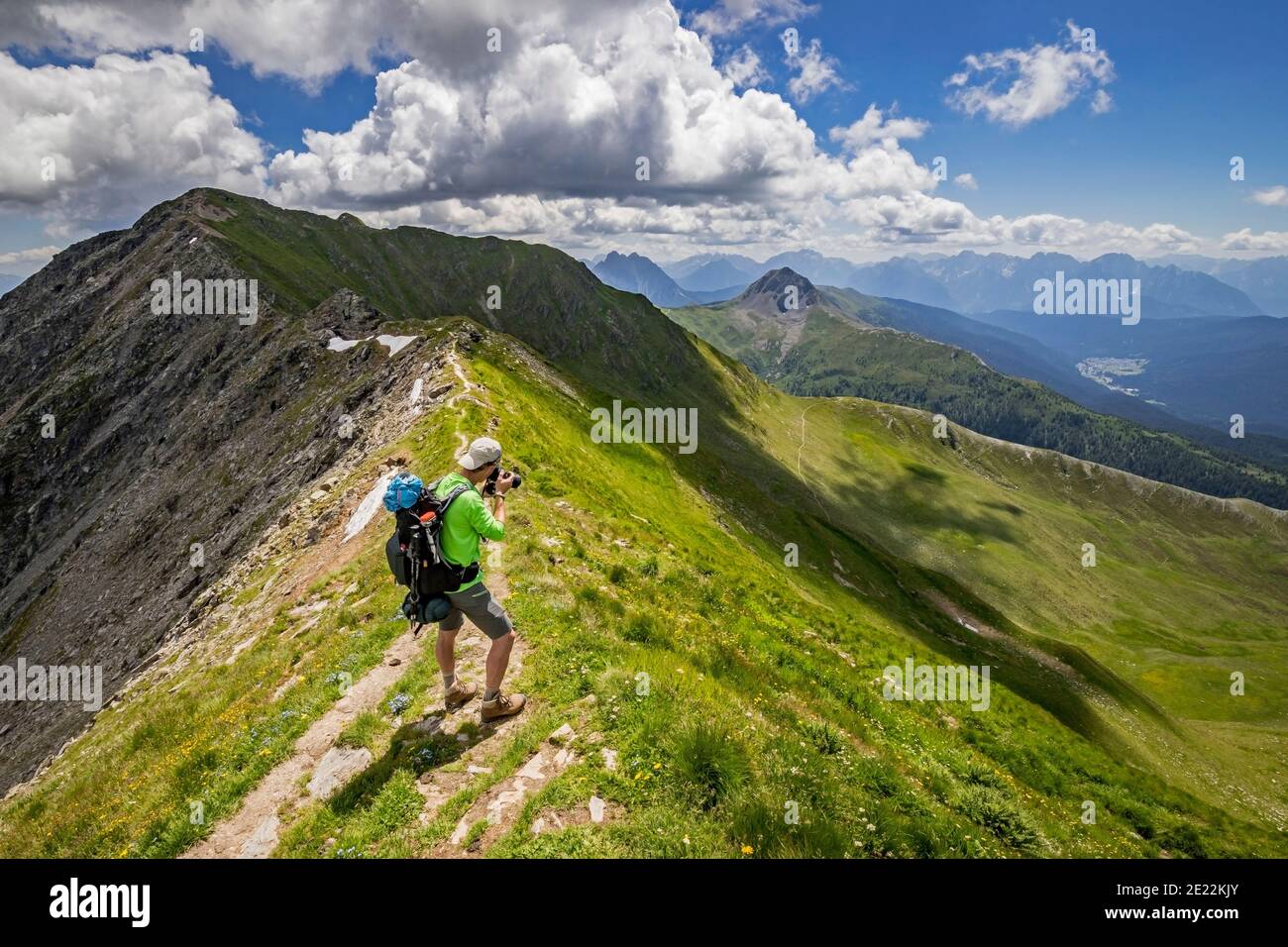 Hiker / mountain walker with backpack taking pictures from ridge of ...