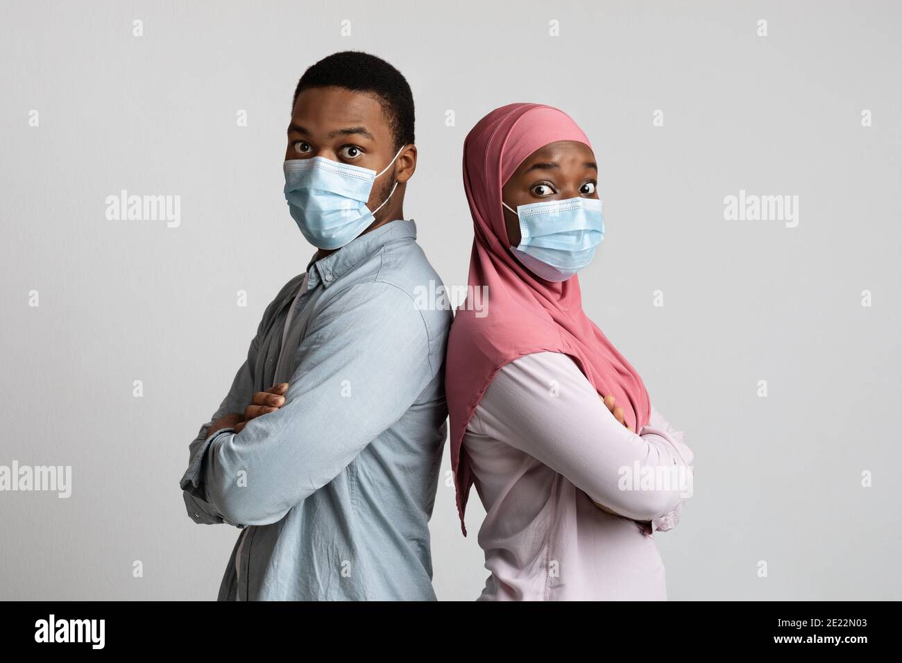 Surprised muslim couple in masks standing back to back Stock Photo - Alamy
