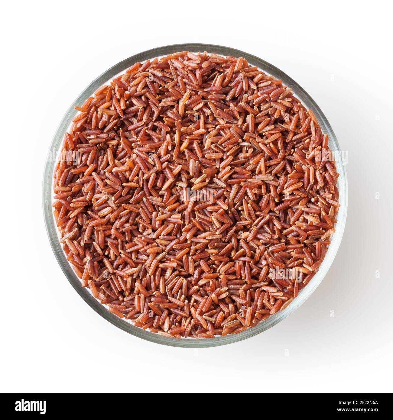 Uncooked red rice in glass bowl isolated on white background with ...