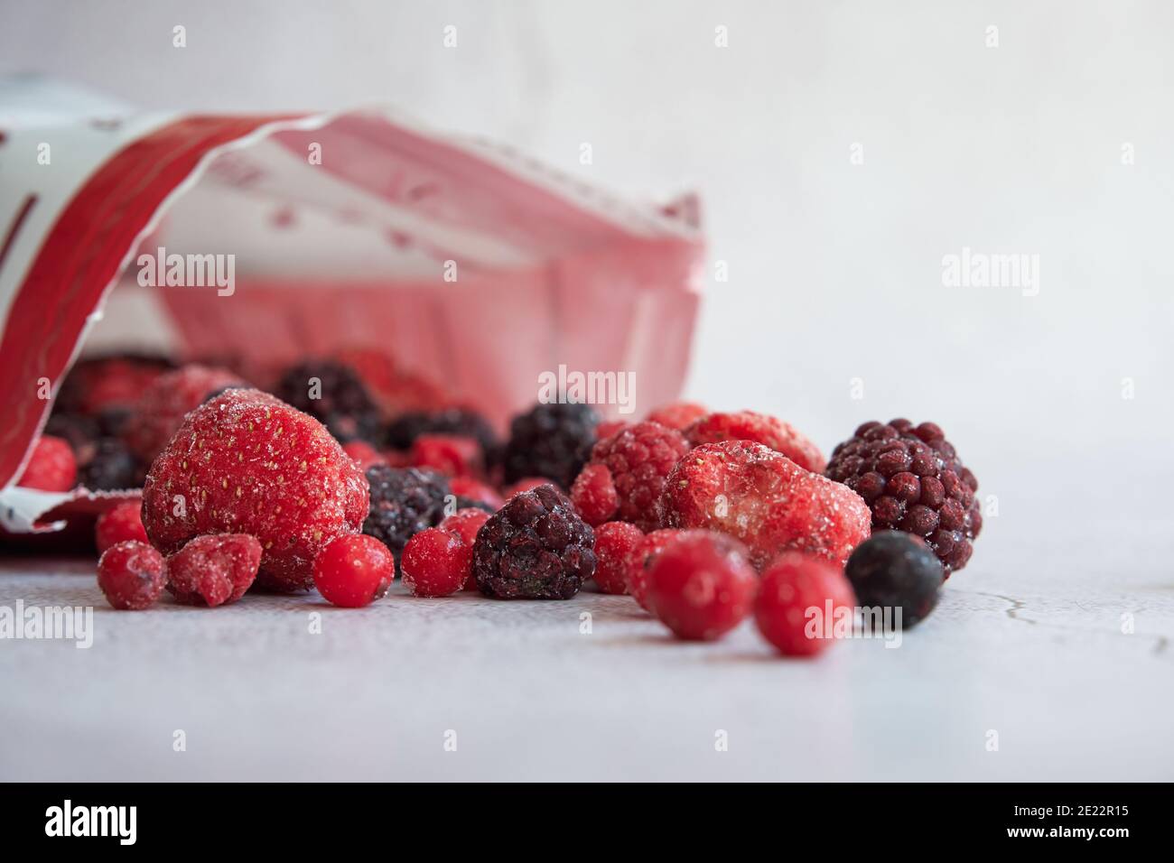 red berries scattered on a white background Stock Photo - Alamy