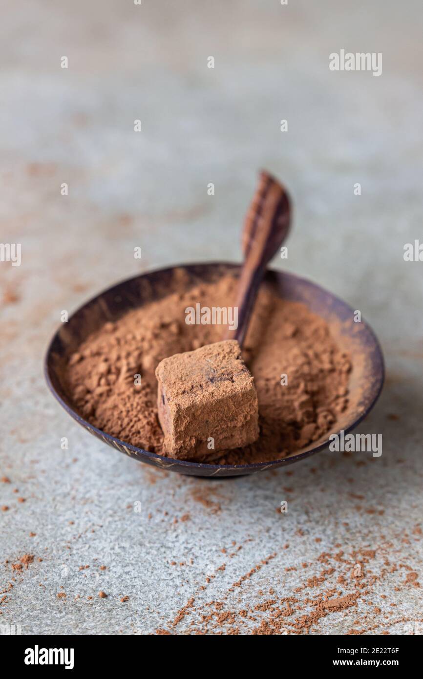 Dark chocolate truffle sprinkled with cocoa powder and cocoa powder in ...