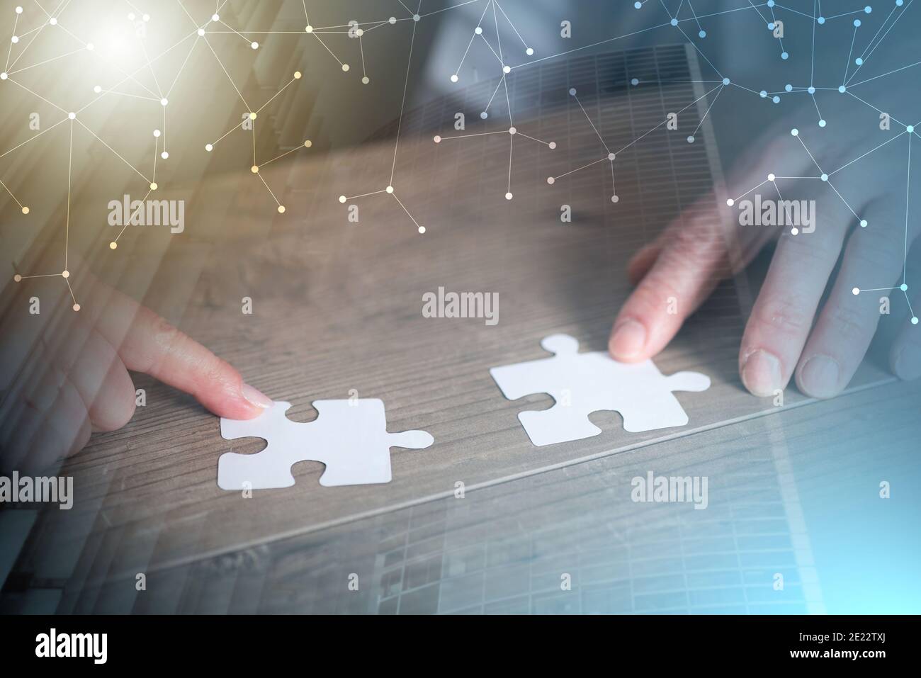 Hands joining two puzzle pieces, teamwork concept; multiple exposure ...