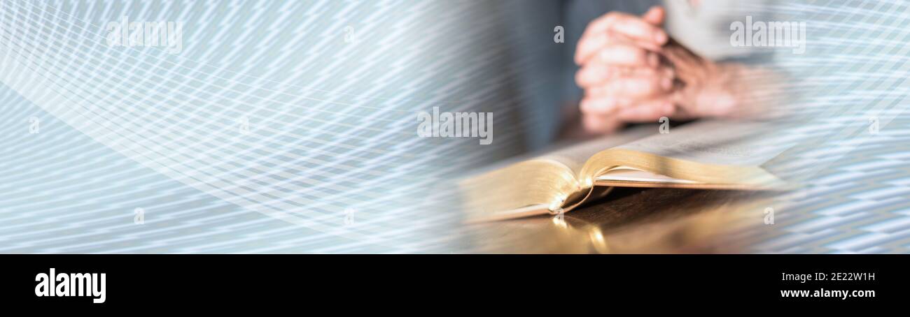 Man praying hands on a bible in dim light; panoramic banner Stock Photo ...