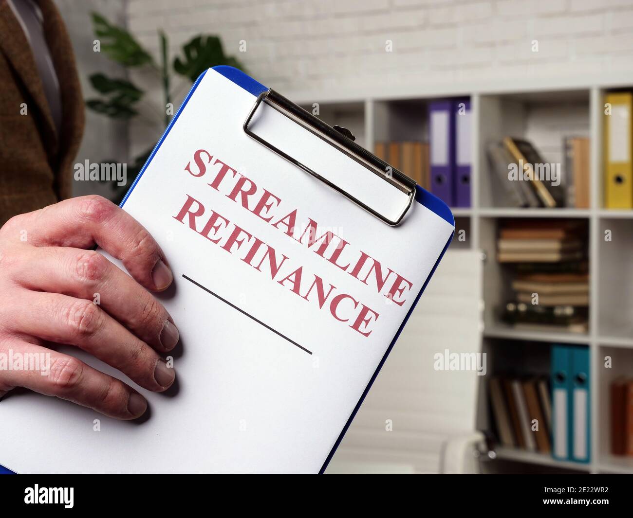 Hand holds papers for Streamline refinance and clipboard Stock Photo ...