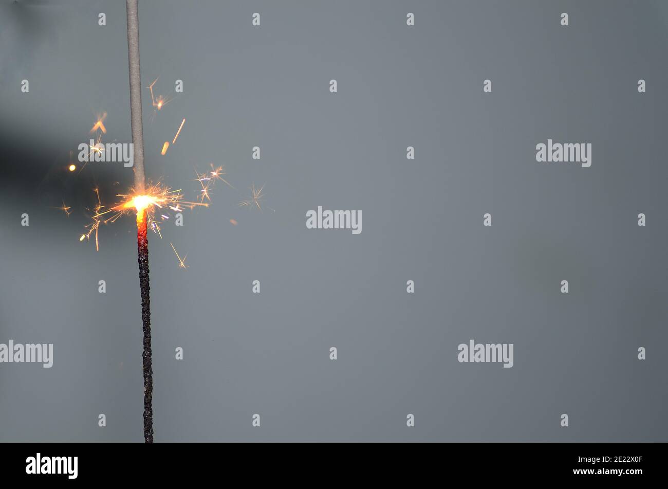 burning sparkler on gray background Stock Photo - Alamy