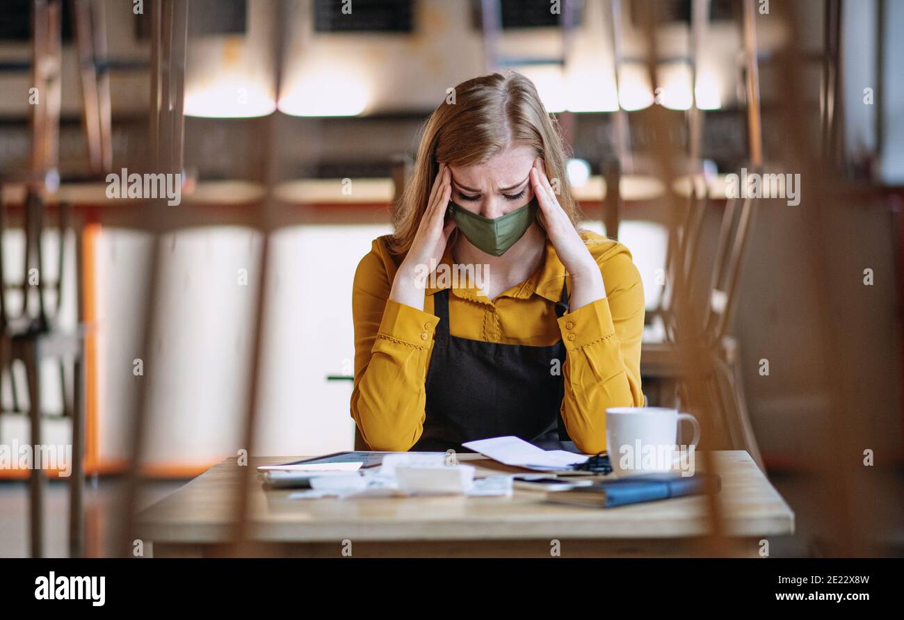 Frustrated owner sitting at table in closed cafe, small business ...
