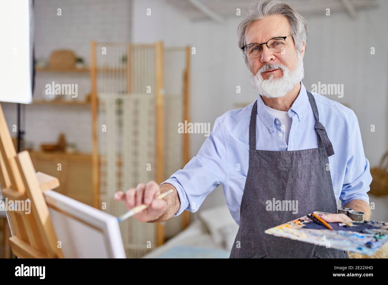 artist holding creating masterpiece using paintbrush, stand near canvas ...