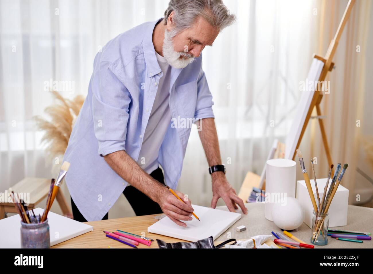 skilled painter drawing sketch on sheet with pencil, tool and materials ...