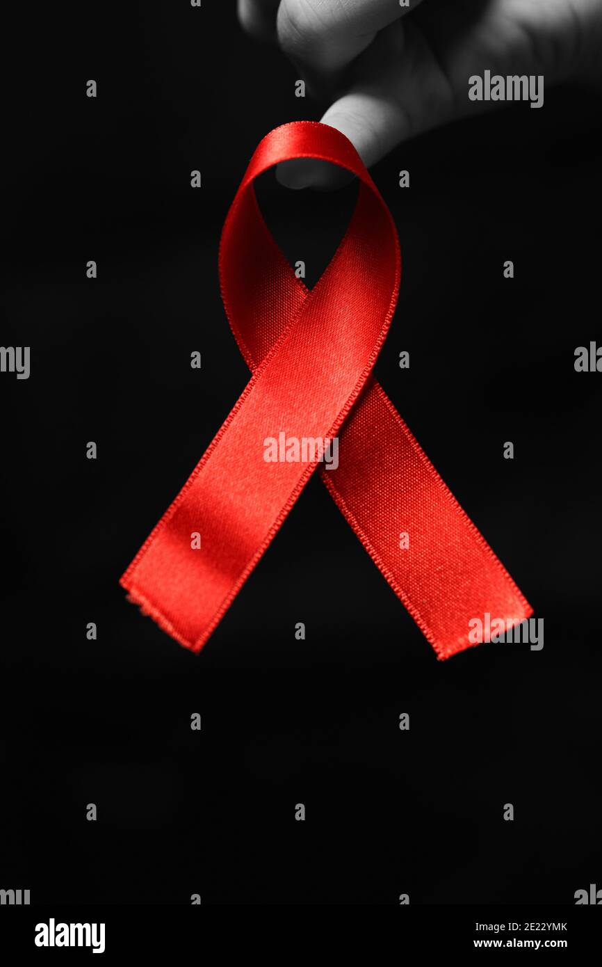 red ribbon on the finger on dark background Stock Photo - Alamy