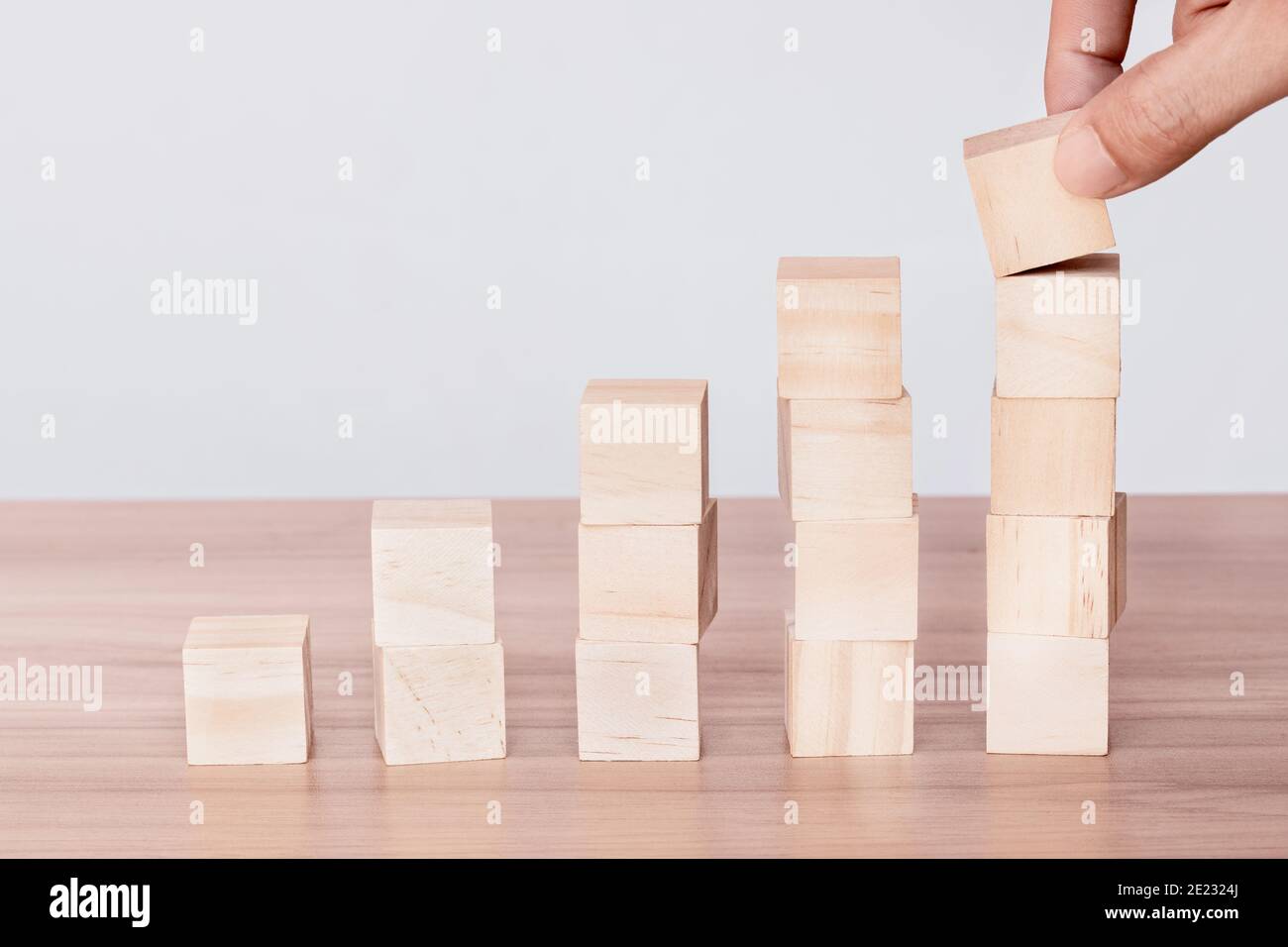 Hand putting and stacking blank wooden cubes on the table with copy ...