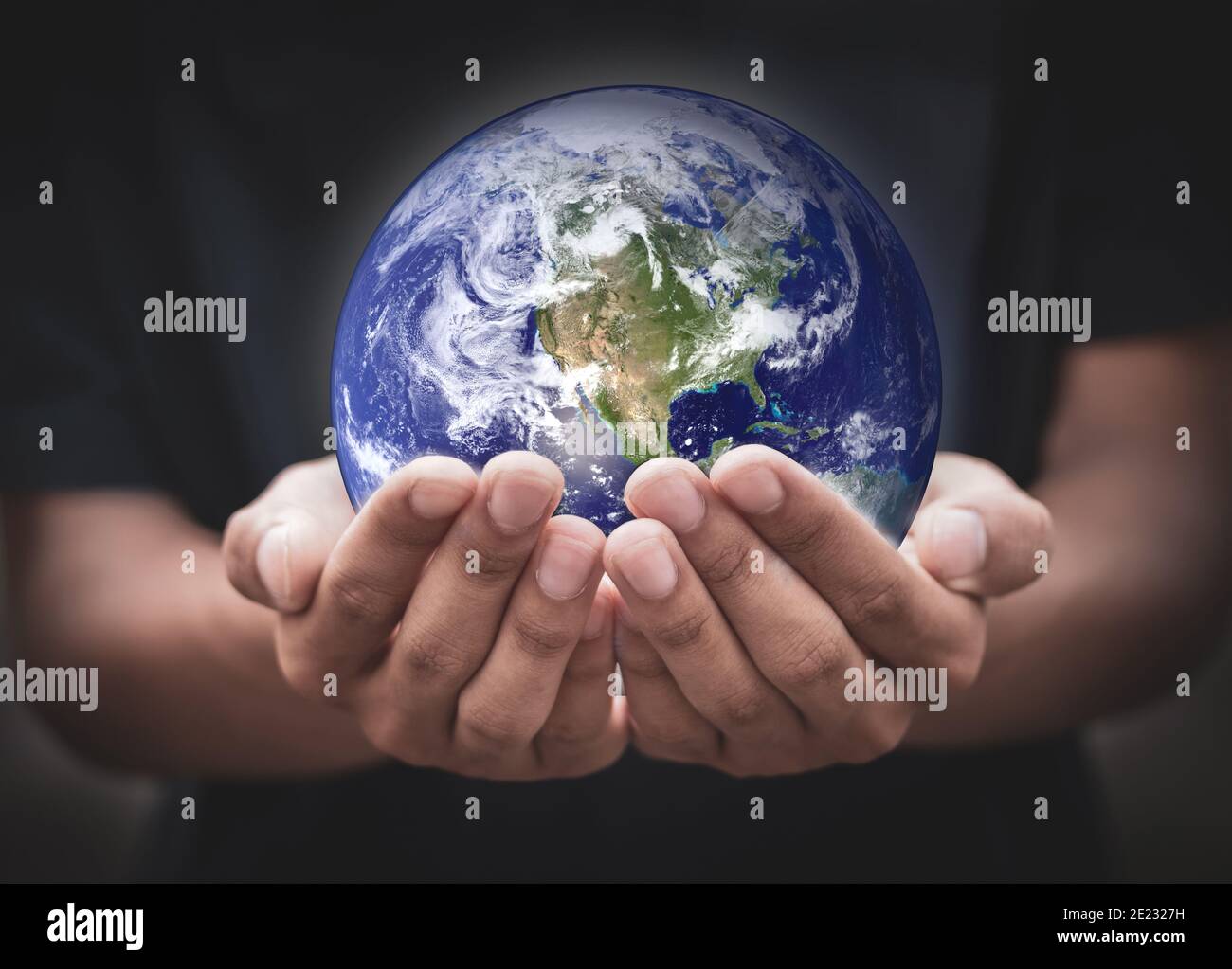 Earth day. Human hands holding global over blurred black background ...