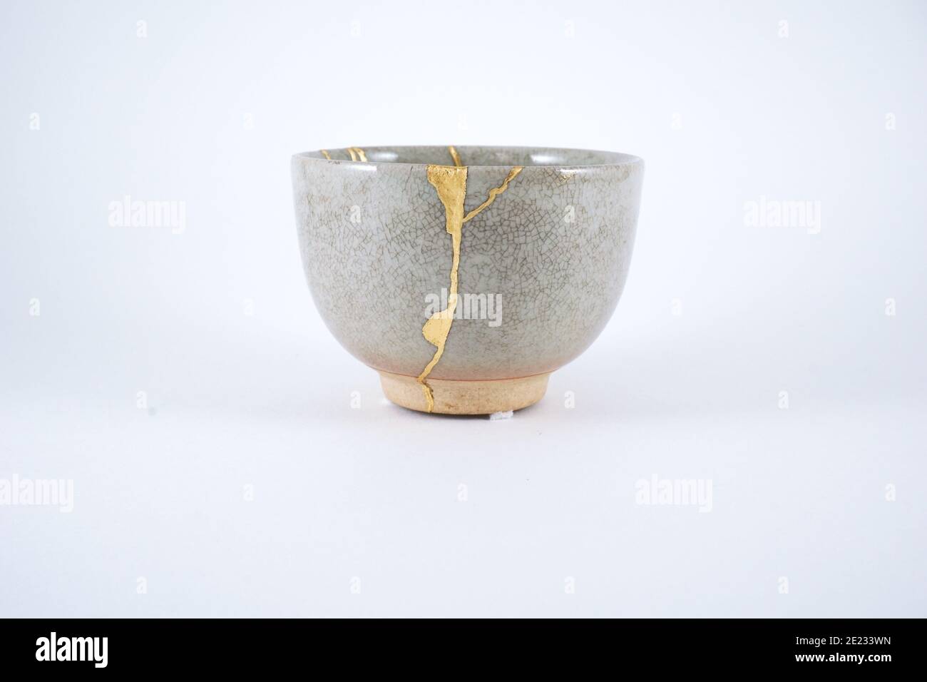 Japanese Kintsugi beige tea cup, gold cracks on antique pottery Stock ...