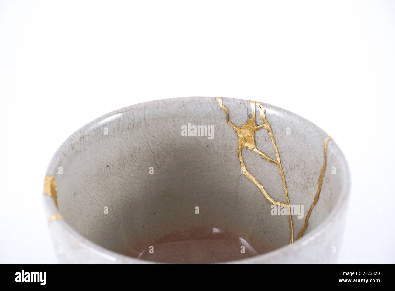 Japanese Kintsugi beige tea cup, gold cracks on antique pottery Stock ...