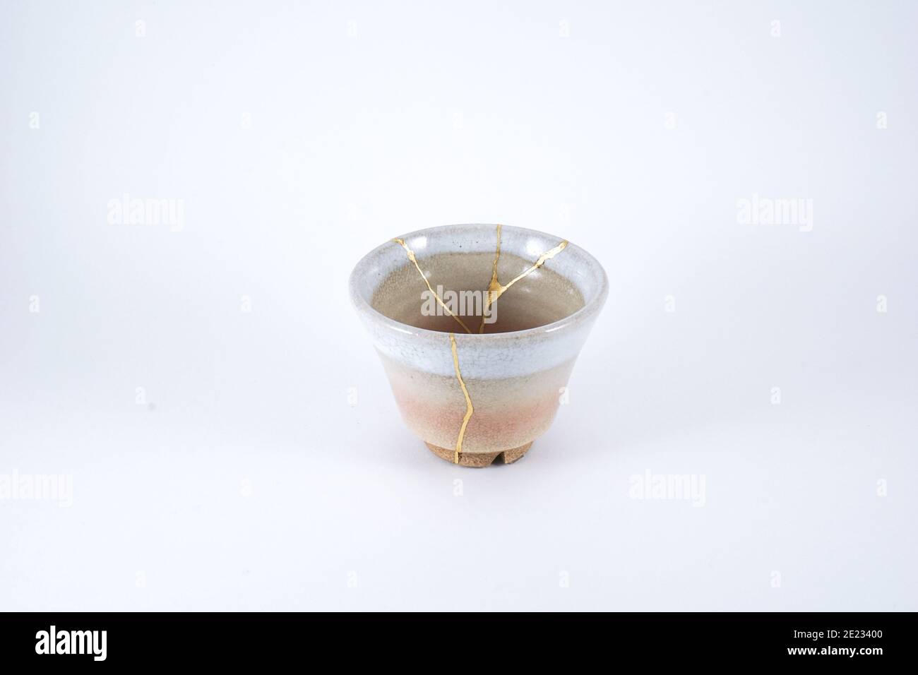 Japanese Kintsugi beige tea cup, gold cracks on antique pottery Stock ...