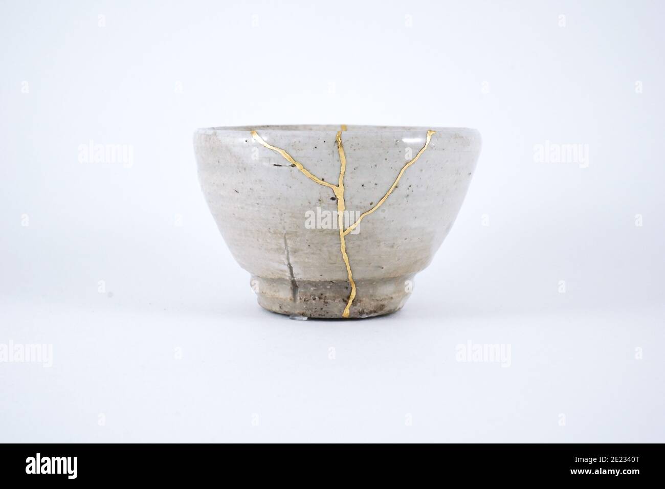 Japanese Kintsugi beige tea cup, gold cracks on antique pottery Stock ...