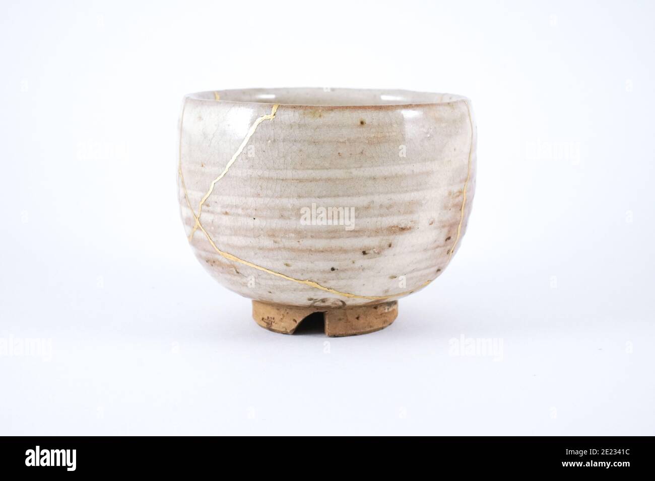 Japanese Kintsugi beige tea cup, gold cracks on antique pottery Stock ...