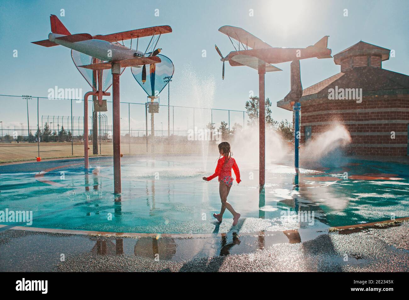 Cute adorable Caucasian funny girl playing on splash pad playground on ...