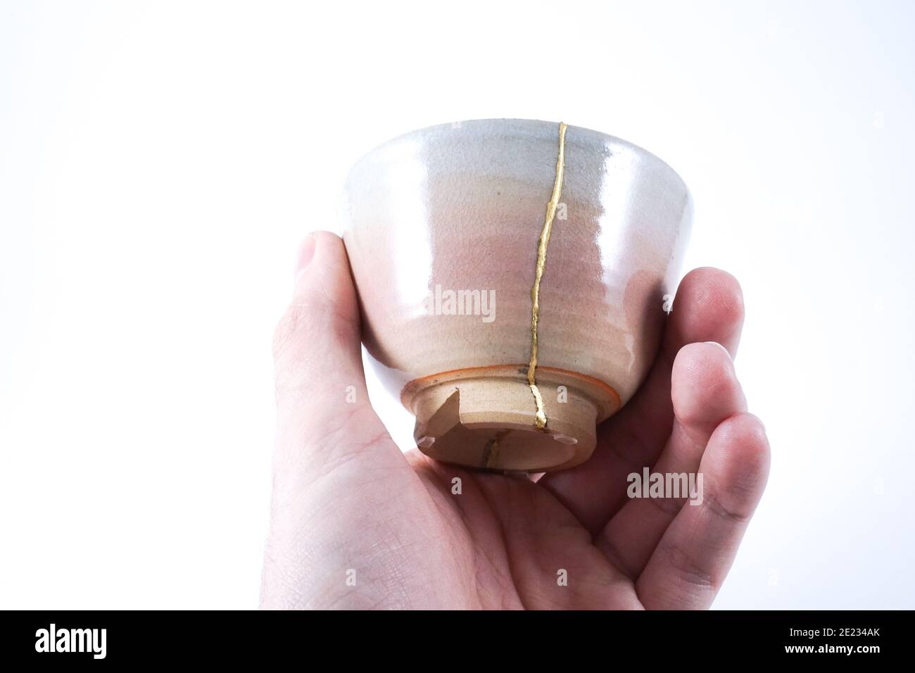 Japanese Kintsugi beige tea cup, gold cracks on antique pottery Stock ...