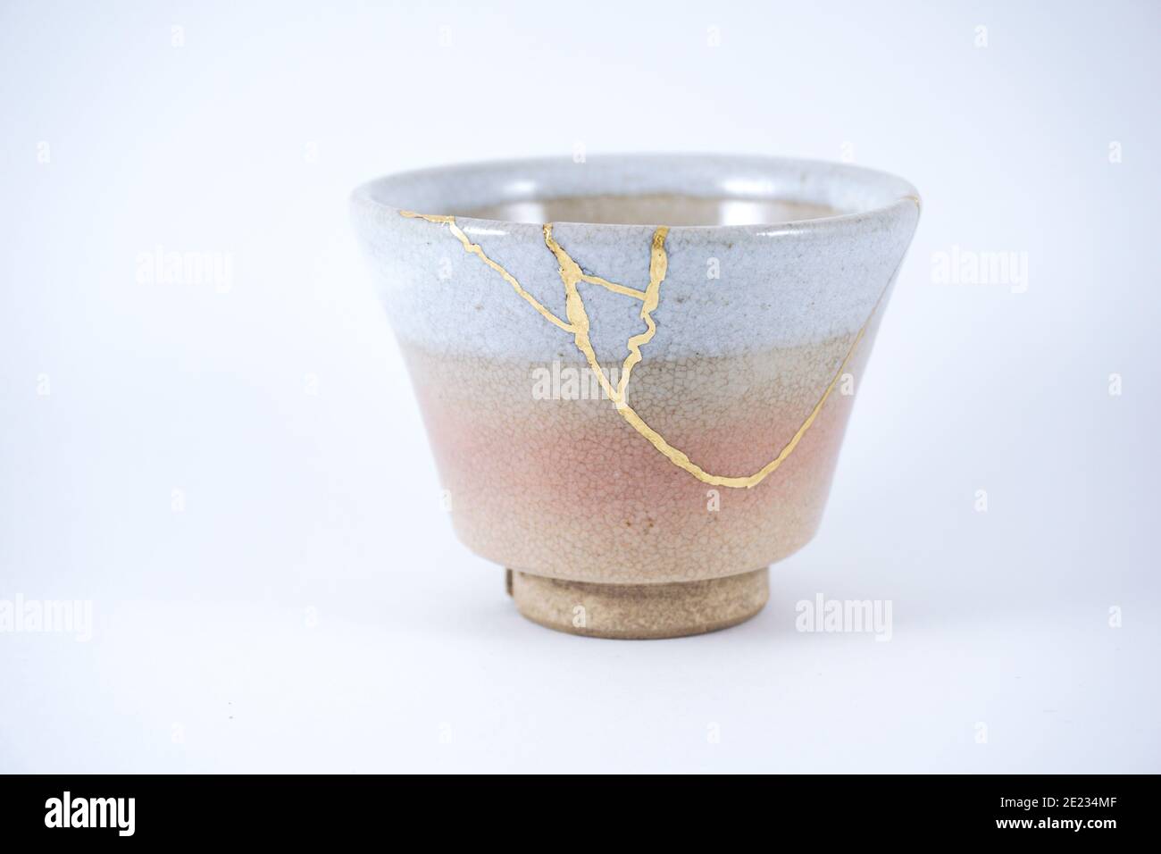 Japanese Kintsugi beige tea cup, gold cracks on antique pottery Stock ...