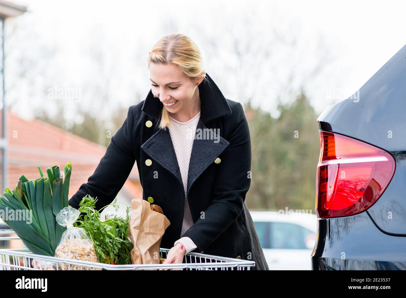 Woman loading groceries after shopping into trunk of her car Stock ...
