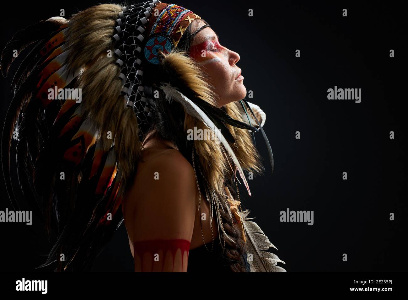 side view on calm indian shaman woman standing with closed eyes ...