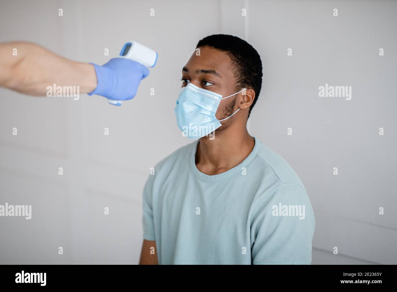 Doctor or nurse using infrared thermometer to measure temperature of ...