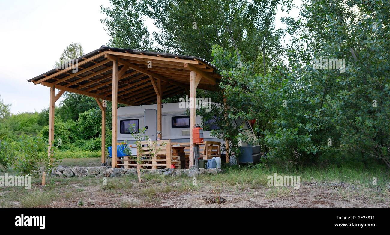 Caravan trailer camping on a green lawn under a tree in springtime ...