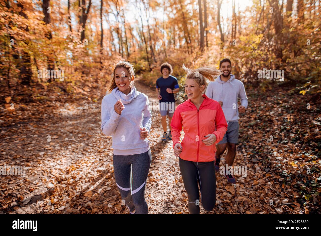 Organized small group of people running in woods in autumn Stock Photo ...