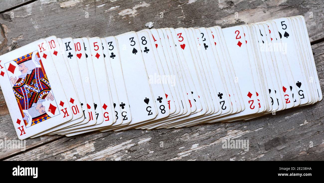 Pile of playing cards at a rustic wooden board Stock Photo - Alamy