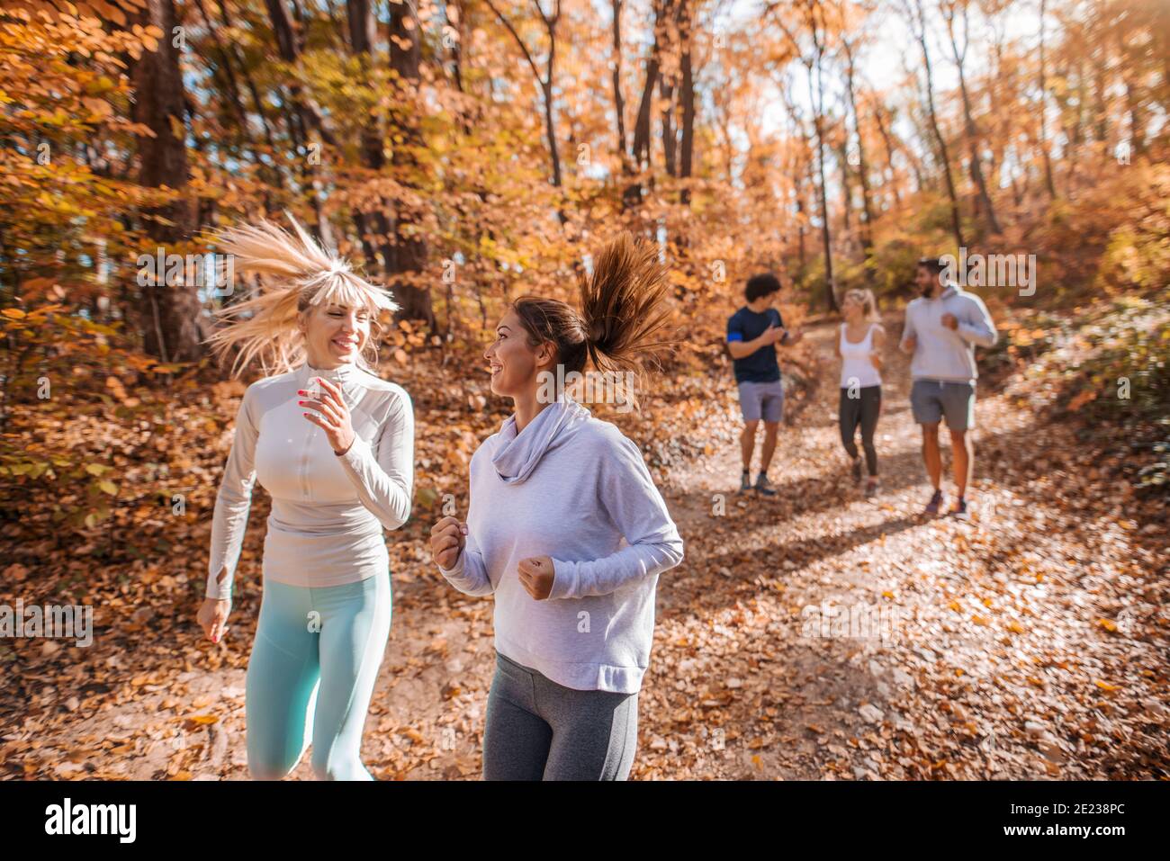 Organized small group of people running in woods in autumn Stock Photo ...
