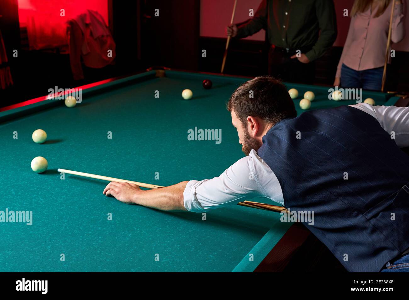 man playing snooker, lining to hit ball on pool billiards table ...