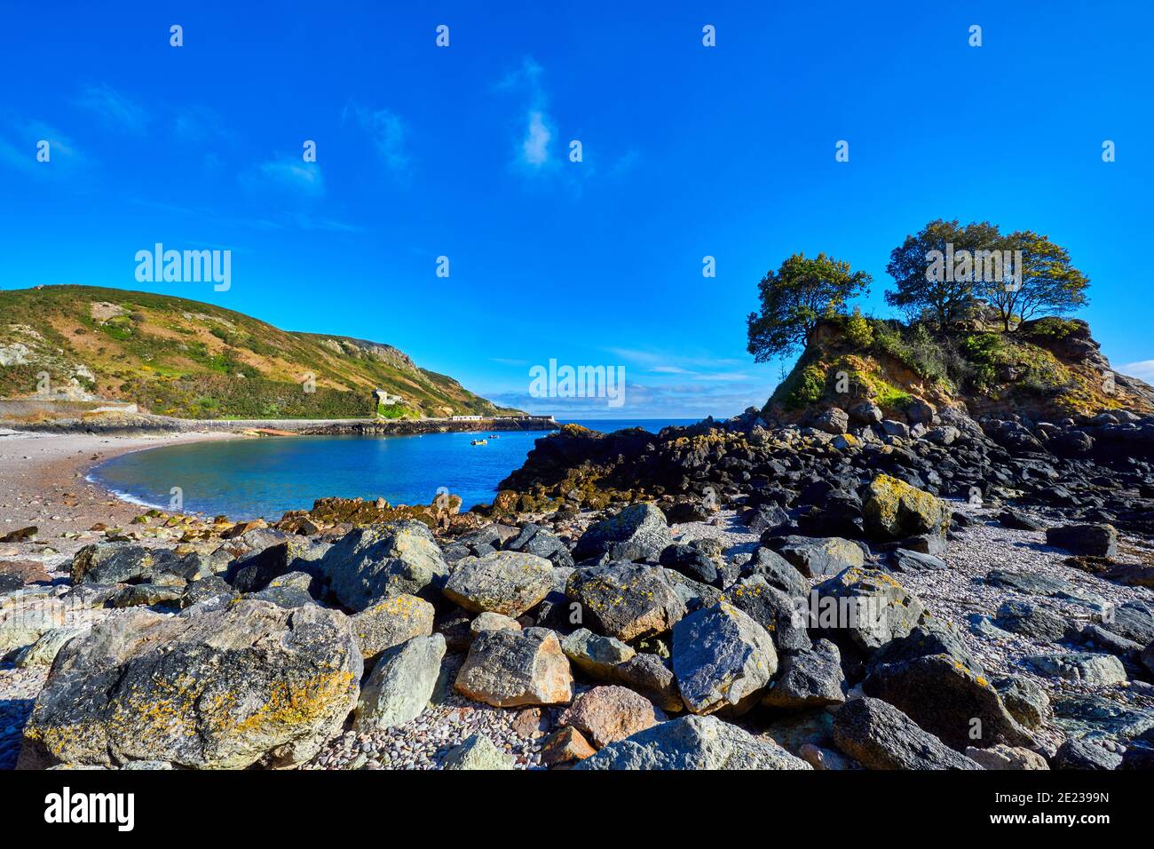 Image of Bouley Bay on a sunny morning with blue sky, pebble beach and ...