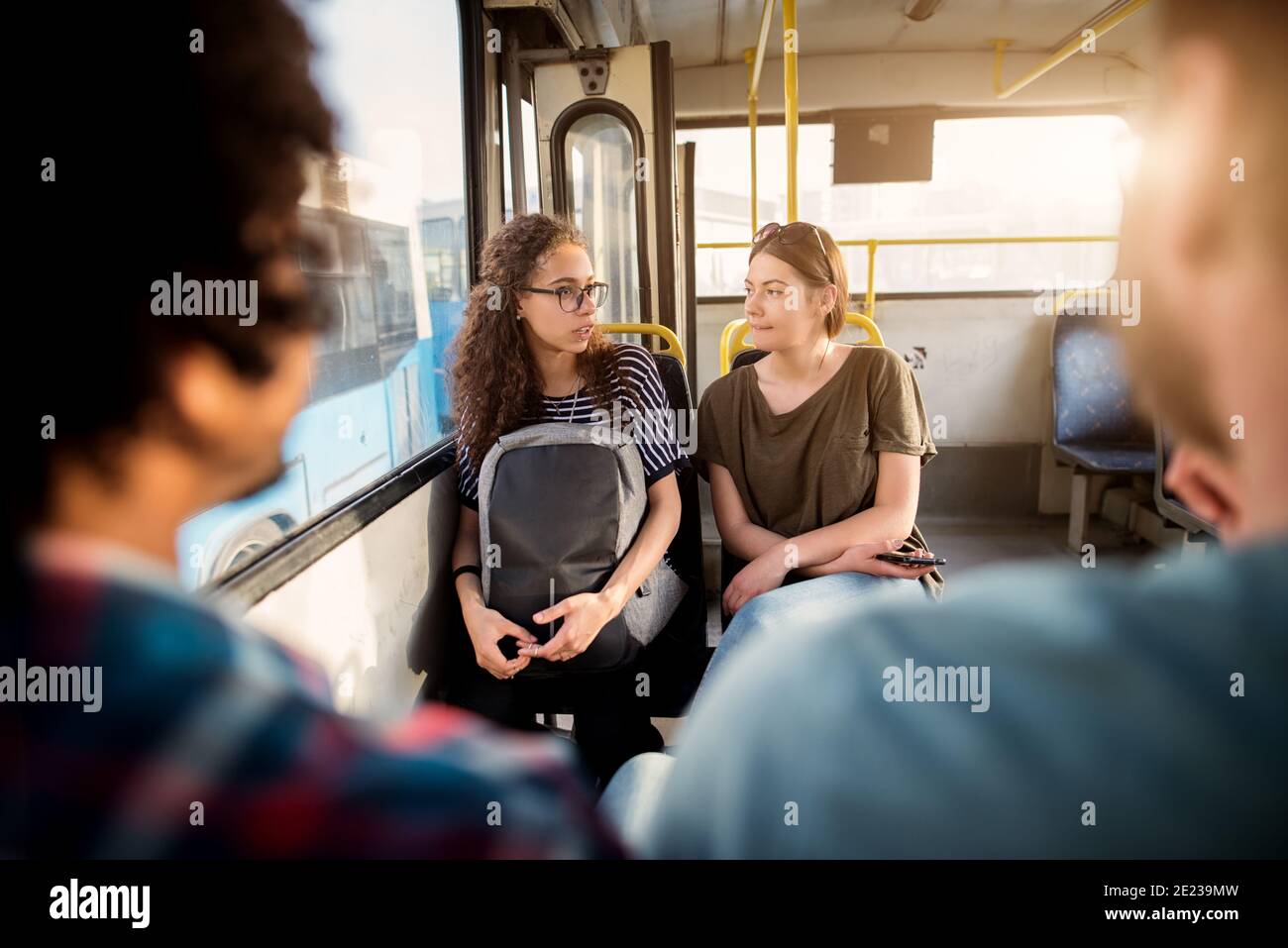 Two young student girls are talking in a bus Stock Photo - Alamy