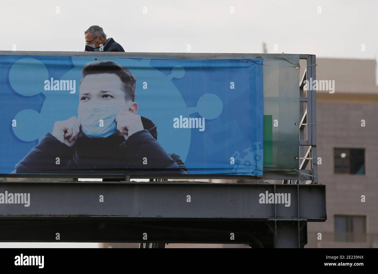Beirut, Lebanon. 11th Jan, 2021. A man is seen behind a poster ...