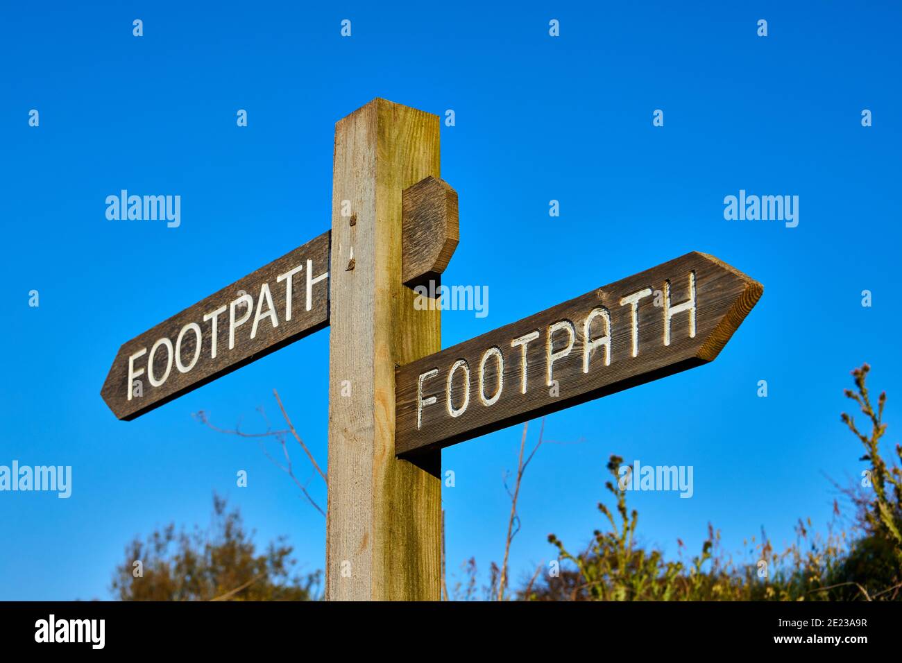 Image of a timber footpath sign with a clear blue sky, whth shallow ...