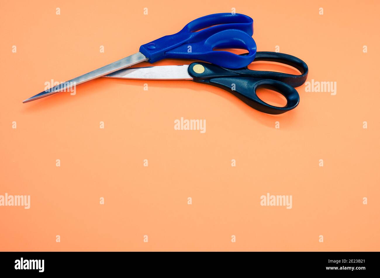 Couple of scissors isolated on an orangbackground Stock Photo - Alamy