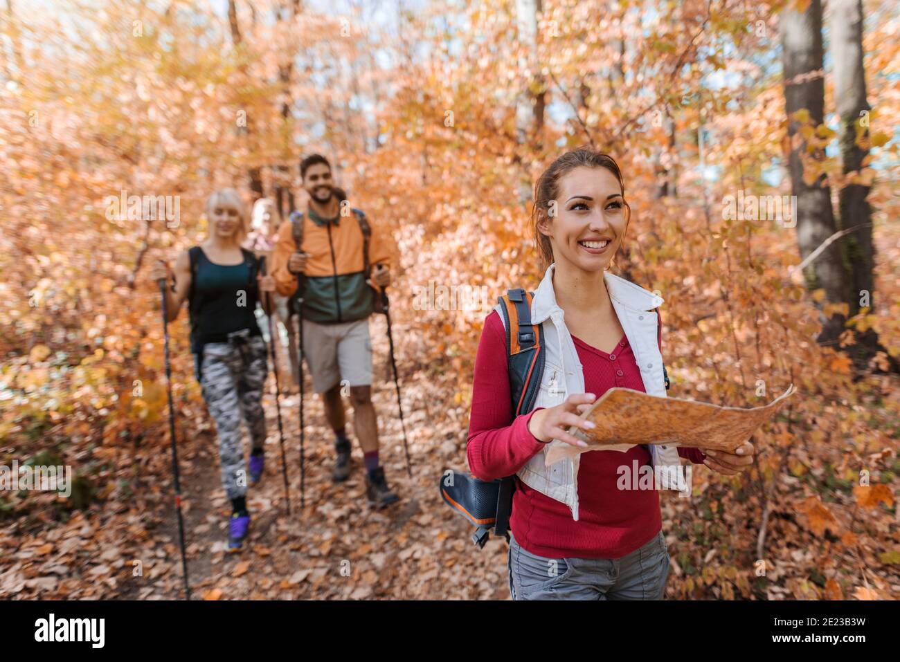 Small happy group of hikers walking in the forest in autumn. Woman ...